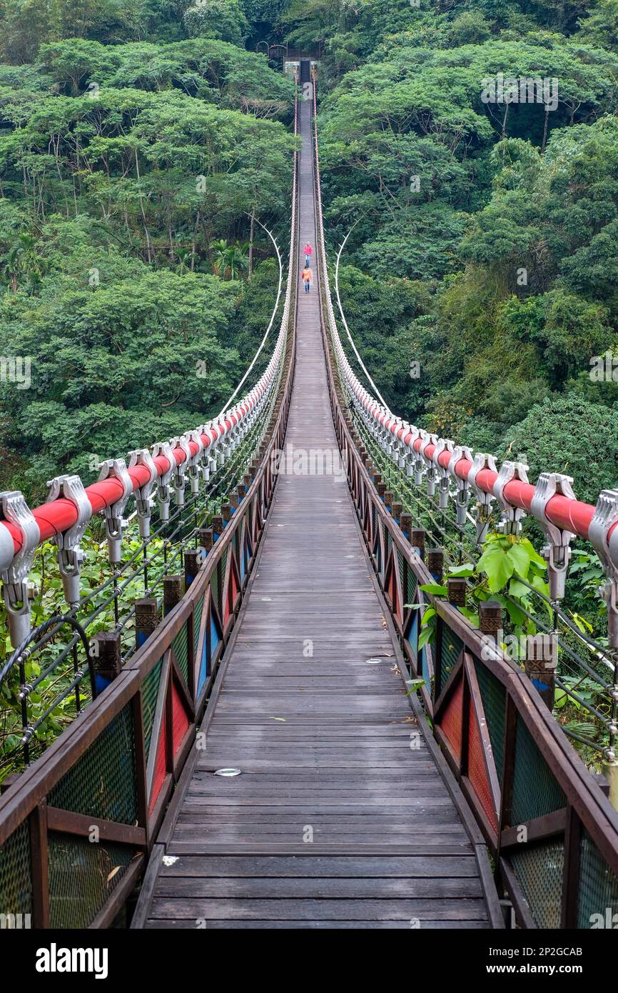 Lady in red crossing the long pedestrian Fumei Suspension Bridge in ...