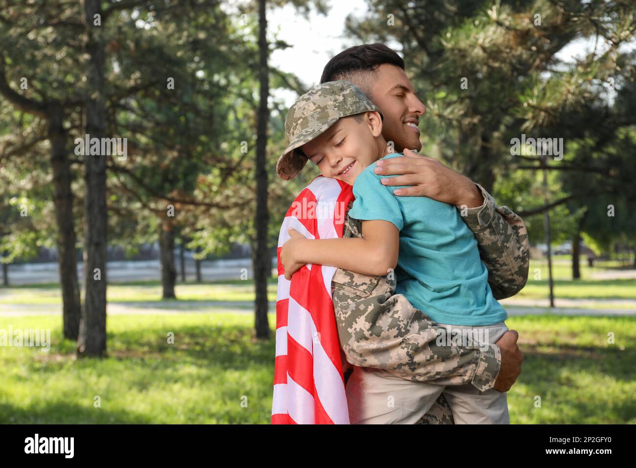 Soldier with flag of USA and his little son hugging outdoors Stock ...