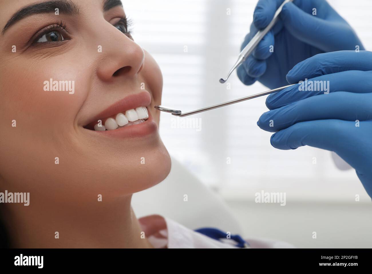 Dentist examining young woman's teeth in clinic, closeup Stock Photo ...