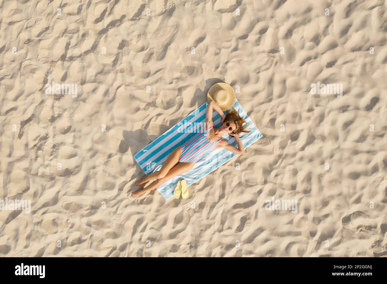 Woman sunbathing on beach towel at sandy coast, aerial view Stock Photo ...
