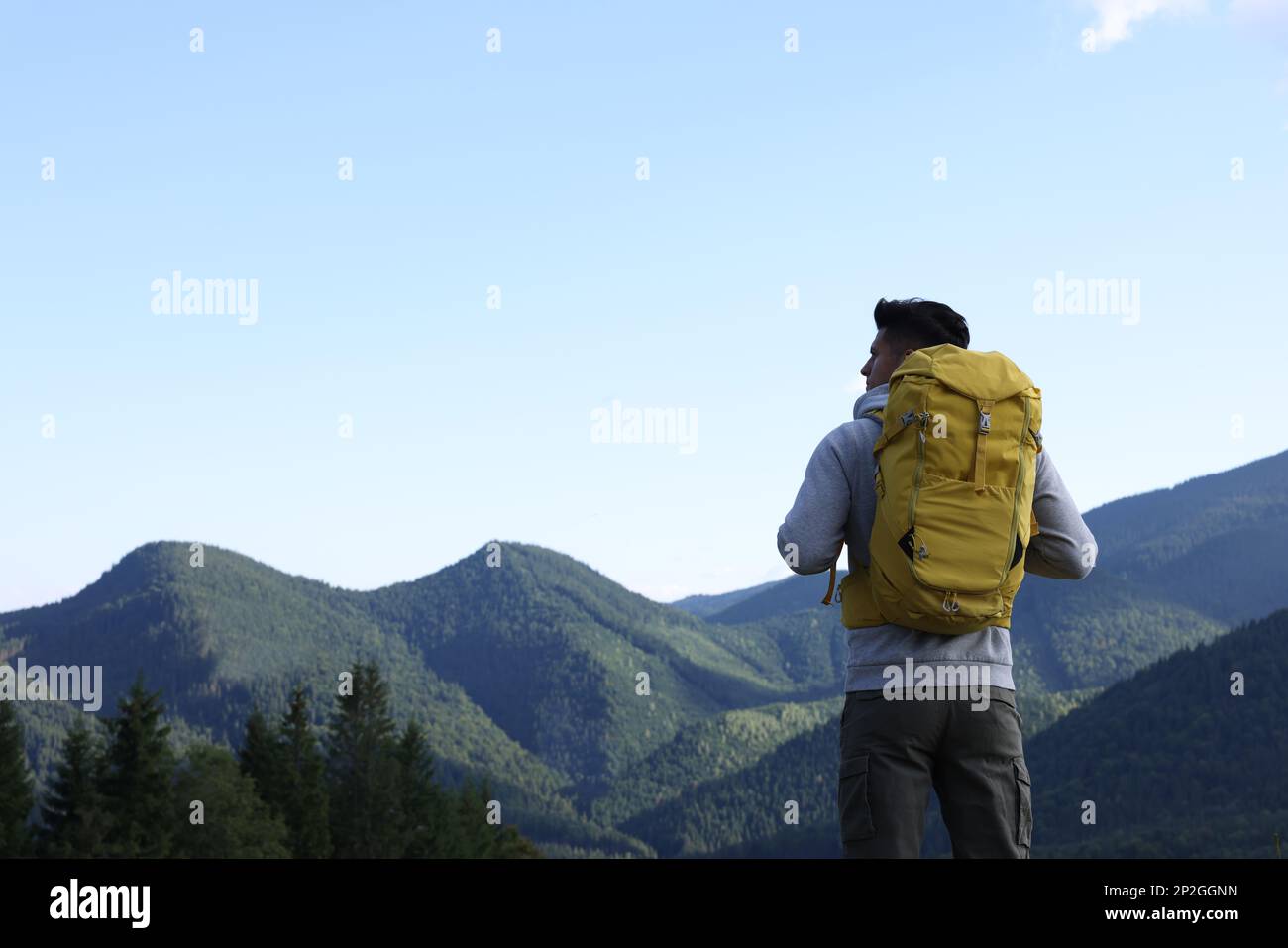 Tourist with backpack enjoying mountain landscape, back view. Space for ...