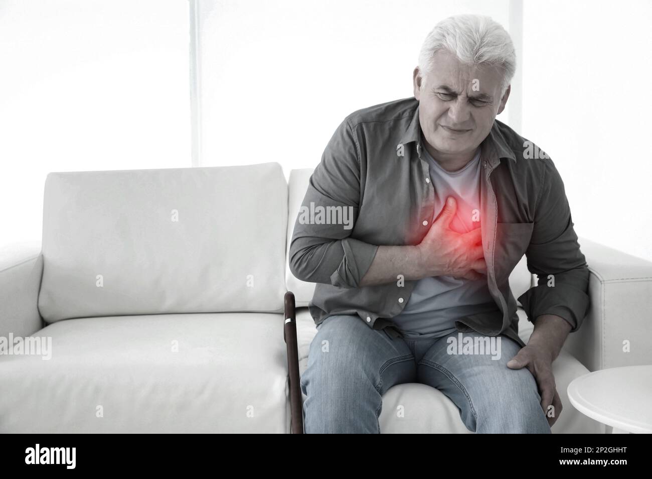 Senior man having heart attack on sofa Stock Photo - Alamy