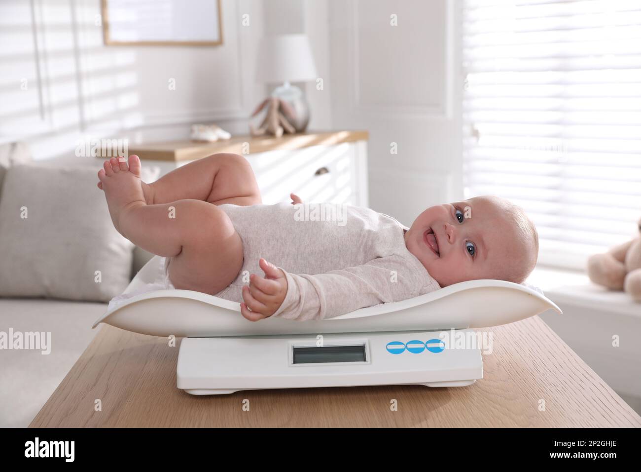 Cute little baby lying on scales at home Stock Photo - Alamy