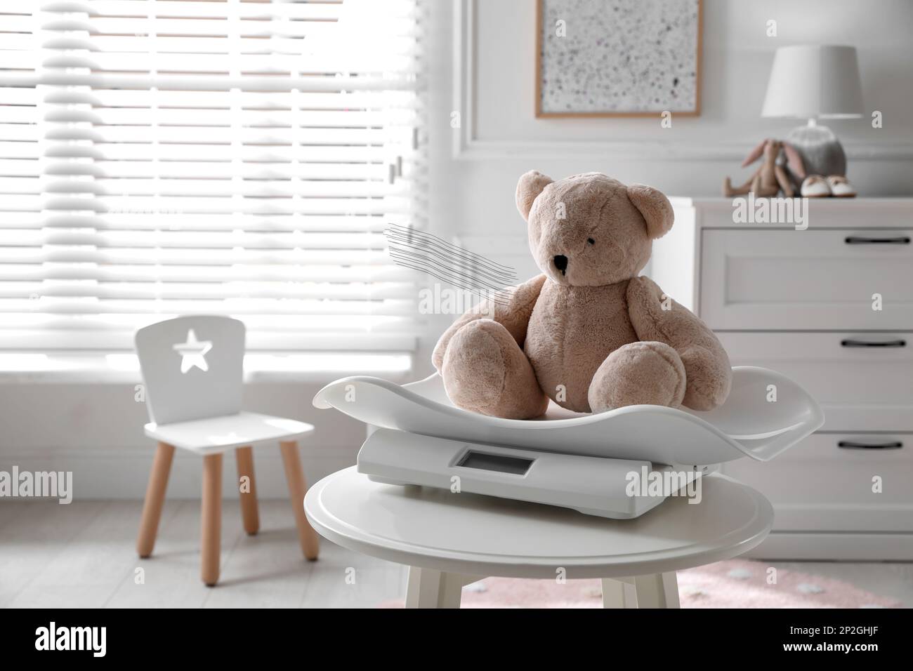 Baby scales with teddy bear on table in room Stock Photo - Alamy