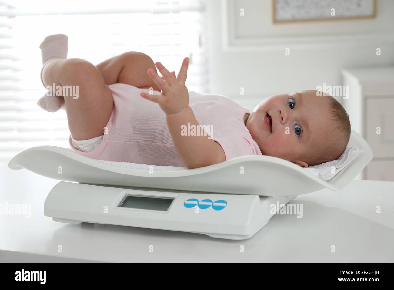 Cute little baby lying on scales at home Stock Photo - Alamy