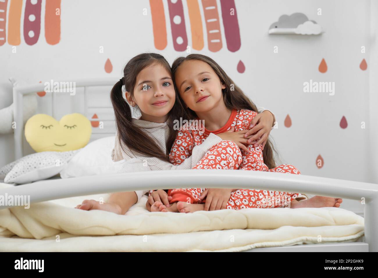 Cute girls in pajamas on bed at home Stock Photo - Alamy