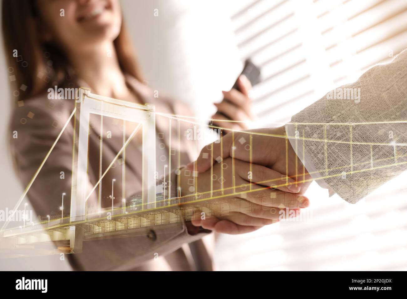 Double exposure of bridge and business partners shaking hands indoors ...