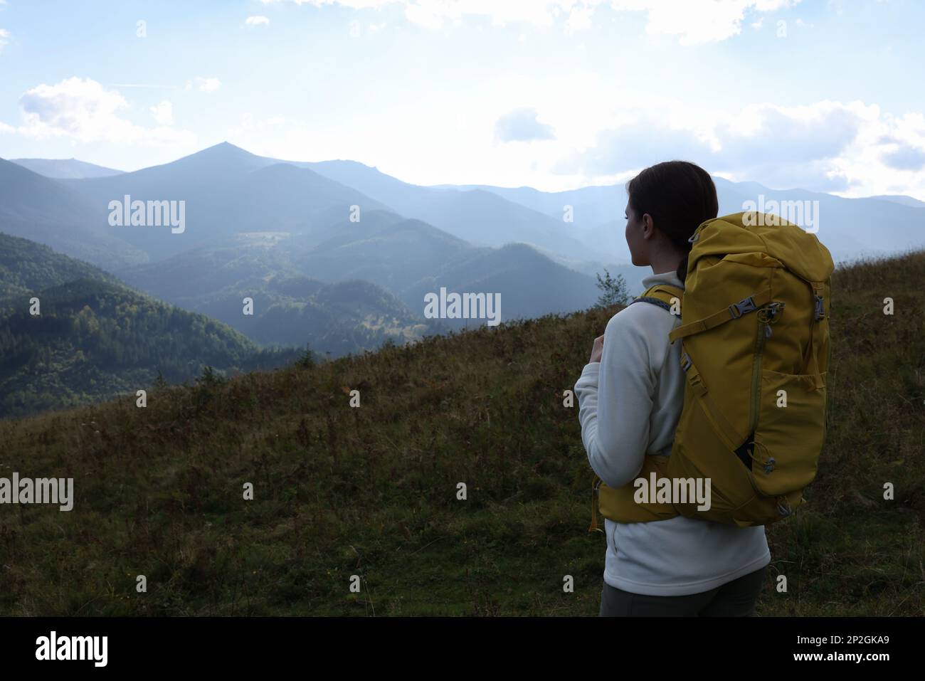Tourist with backpack enjoying mountain landscape, back view. Space for ...