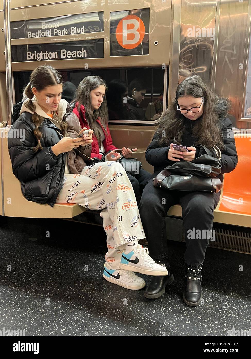 High School girls catch up with their cell phones after school on an ...