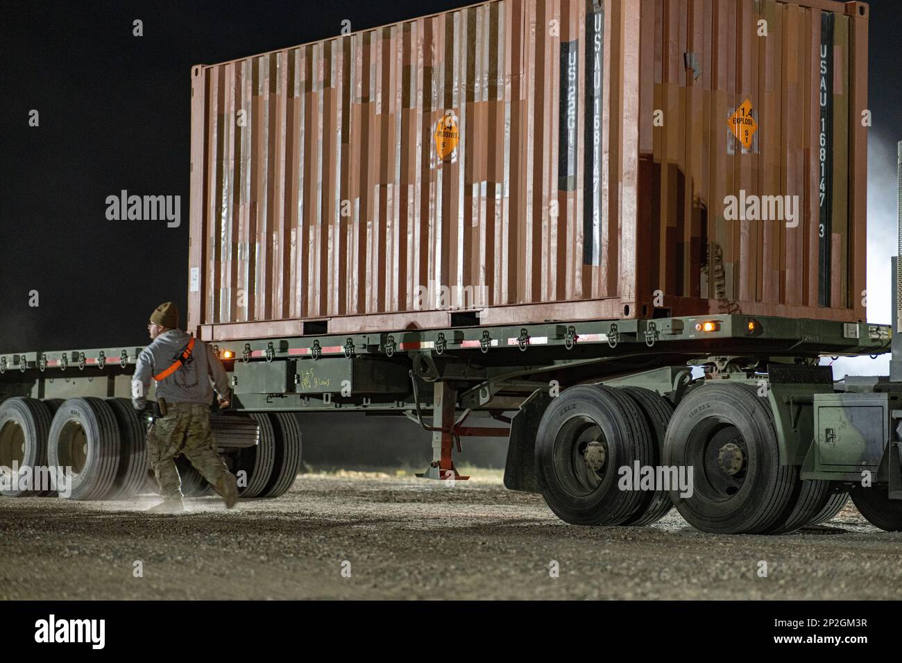 A U.S. Army Soldier guides a M915 truck with trailer out and he ...