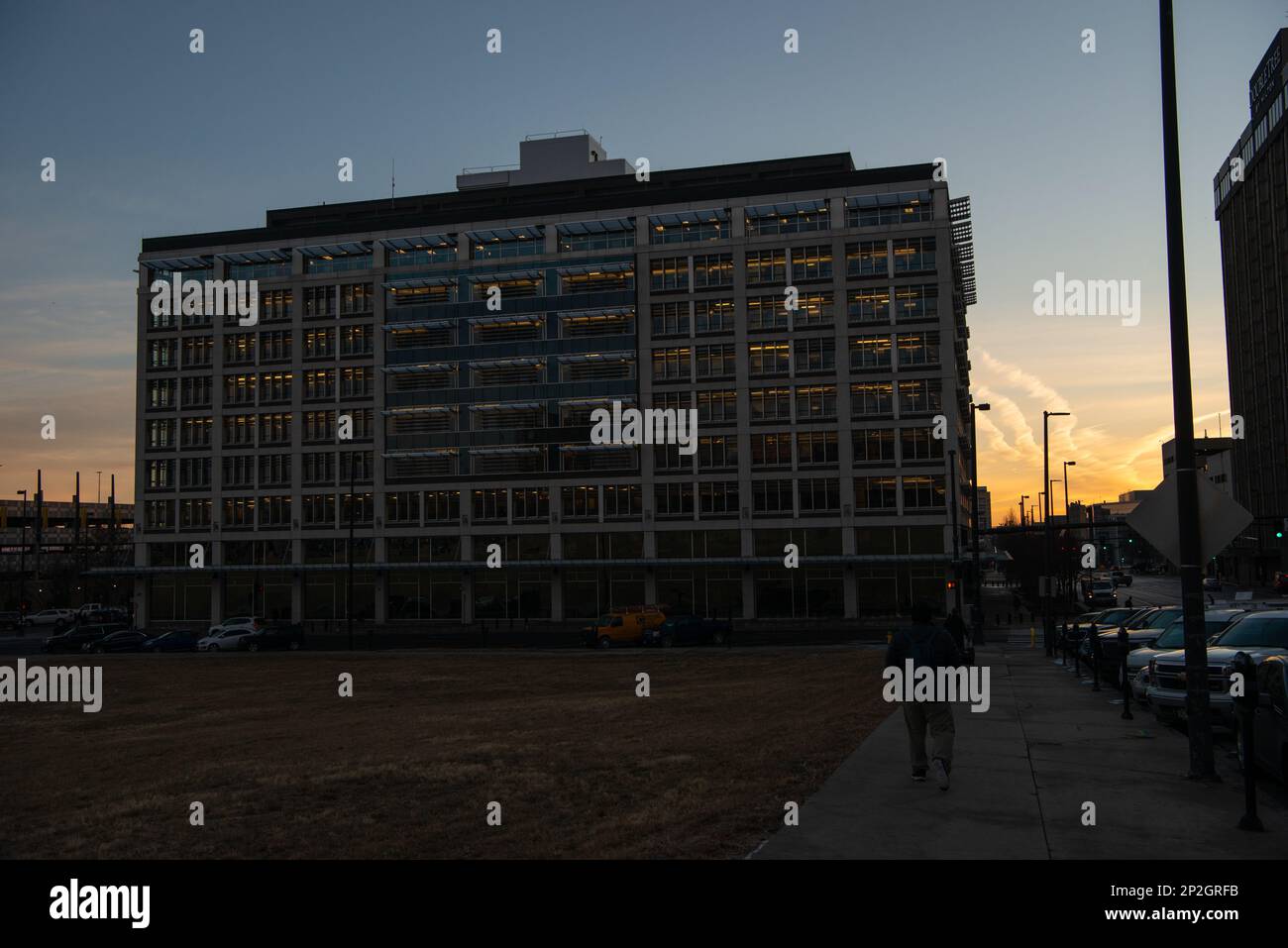 People walk to work while the sun rises over the Edward Zorinsky ...