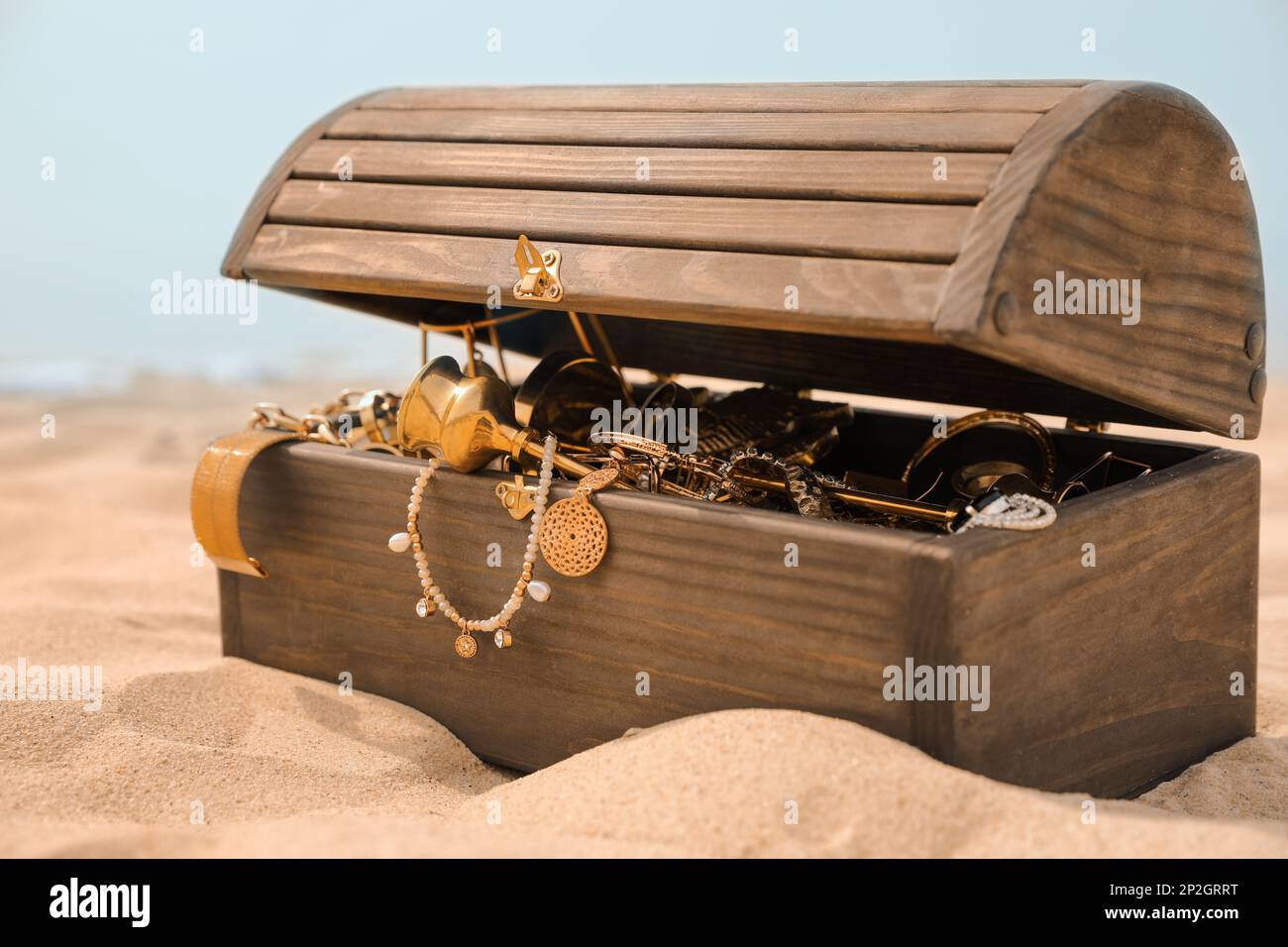 Open wooden treasure chest on sandy beach Stock Photo - Alamy