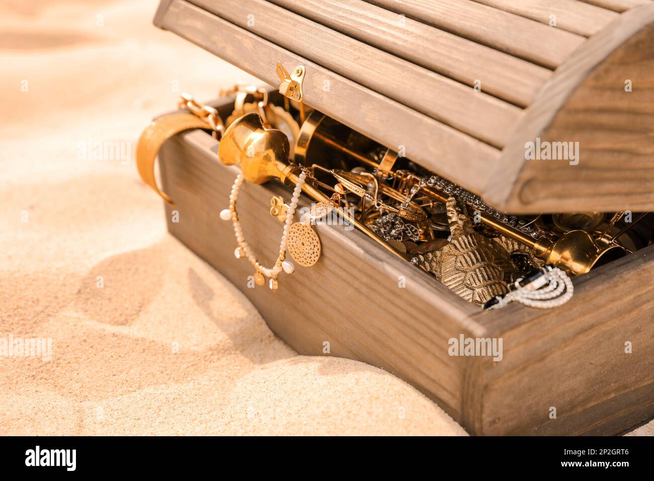 Open wooden treasure chest on sand, closeup Stock Photo - Alamy