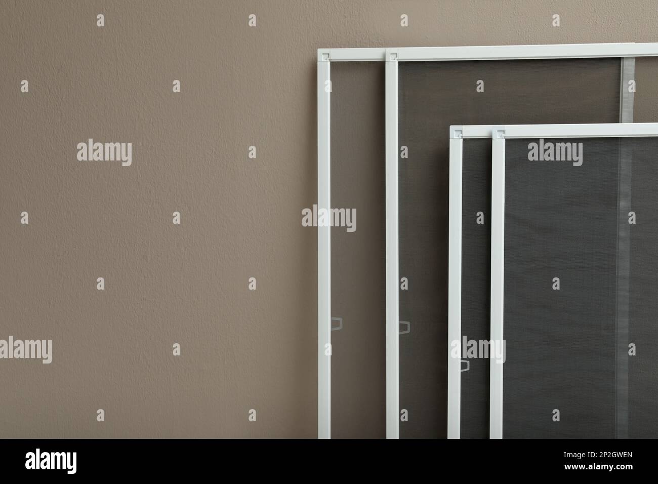 Set of window screens near beige wall. Space for text Stock Photo - Alamy