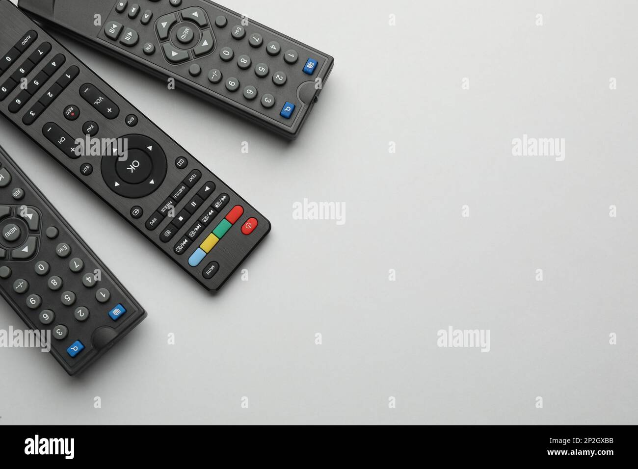 Remote controls on light grey background, flat lay. Space for text ...