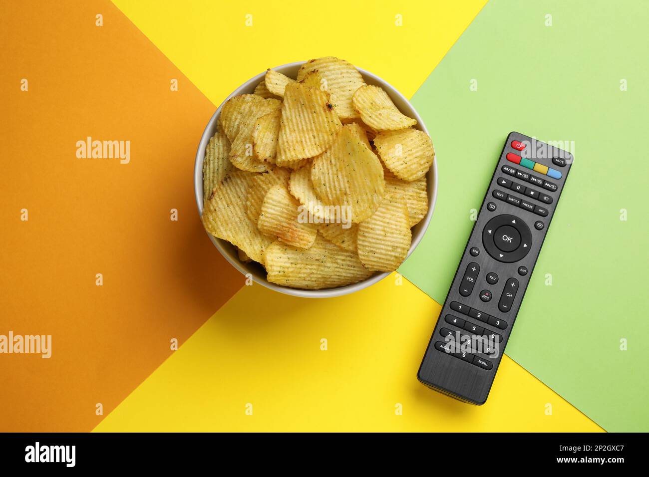 Modern tv remote control and chips on color background, flat lay Stock ...