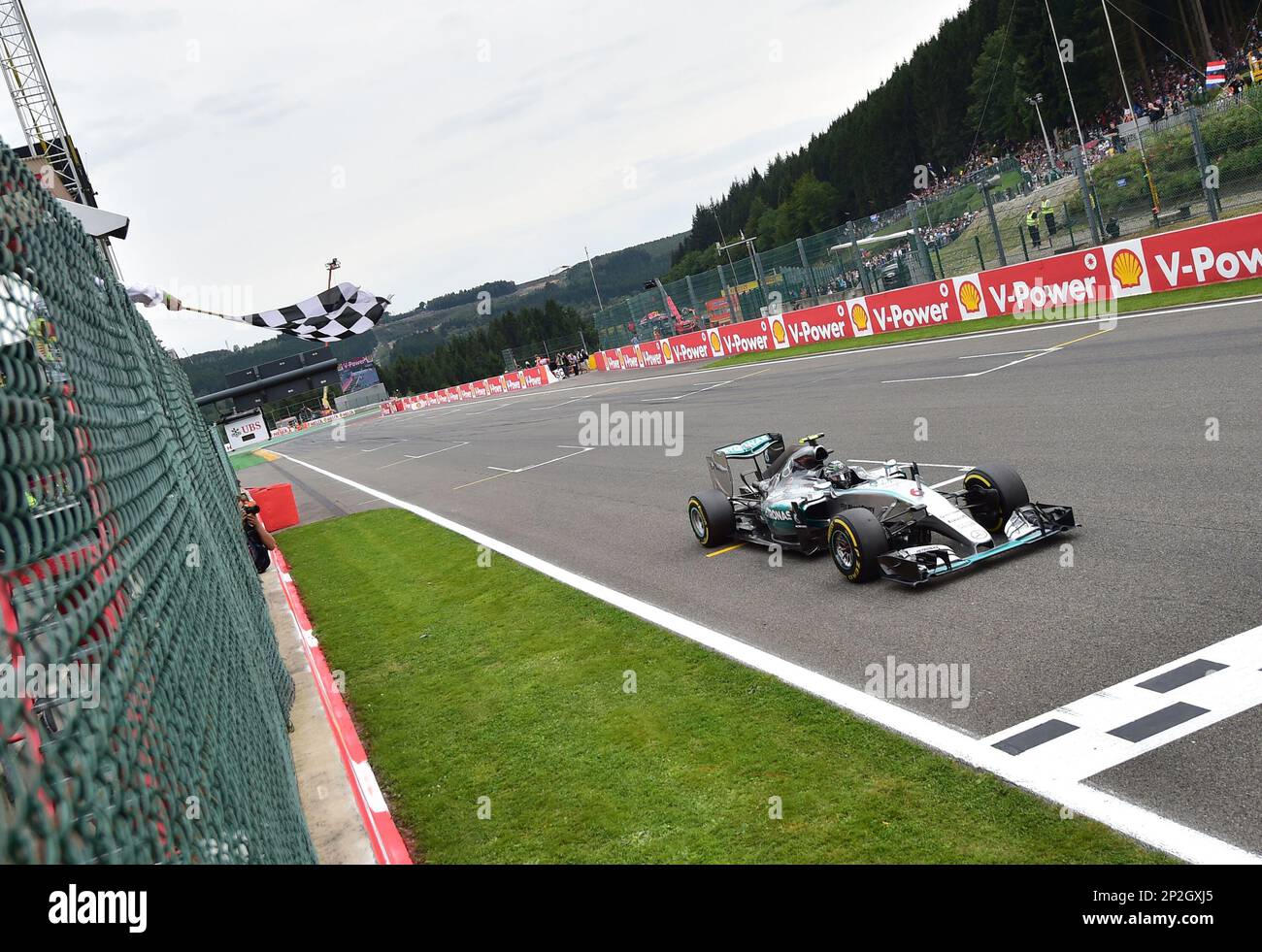 A track marshal waves the checkered flag as Mercedes AMG Petronas F1 ...