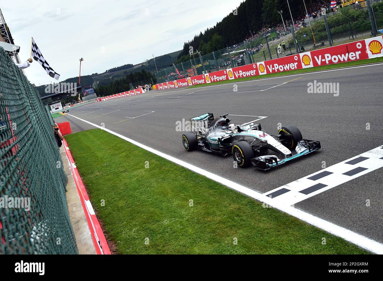 A track marshal waves the checkered flag as Mercedes AMG Petronas F1 ...