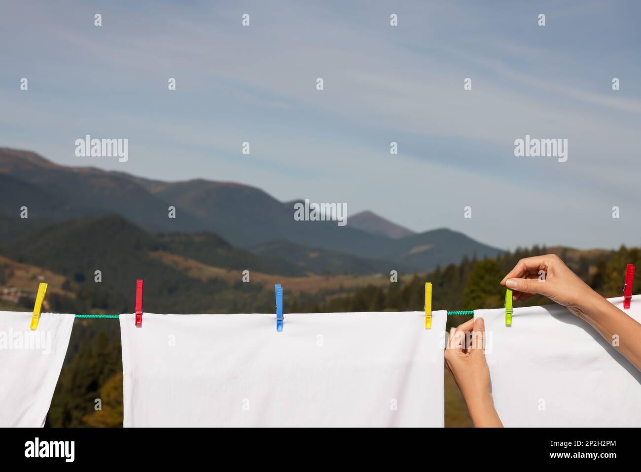 Colorful clothes pins on a laundry rope Stock Photo - Alamy
