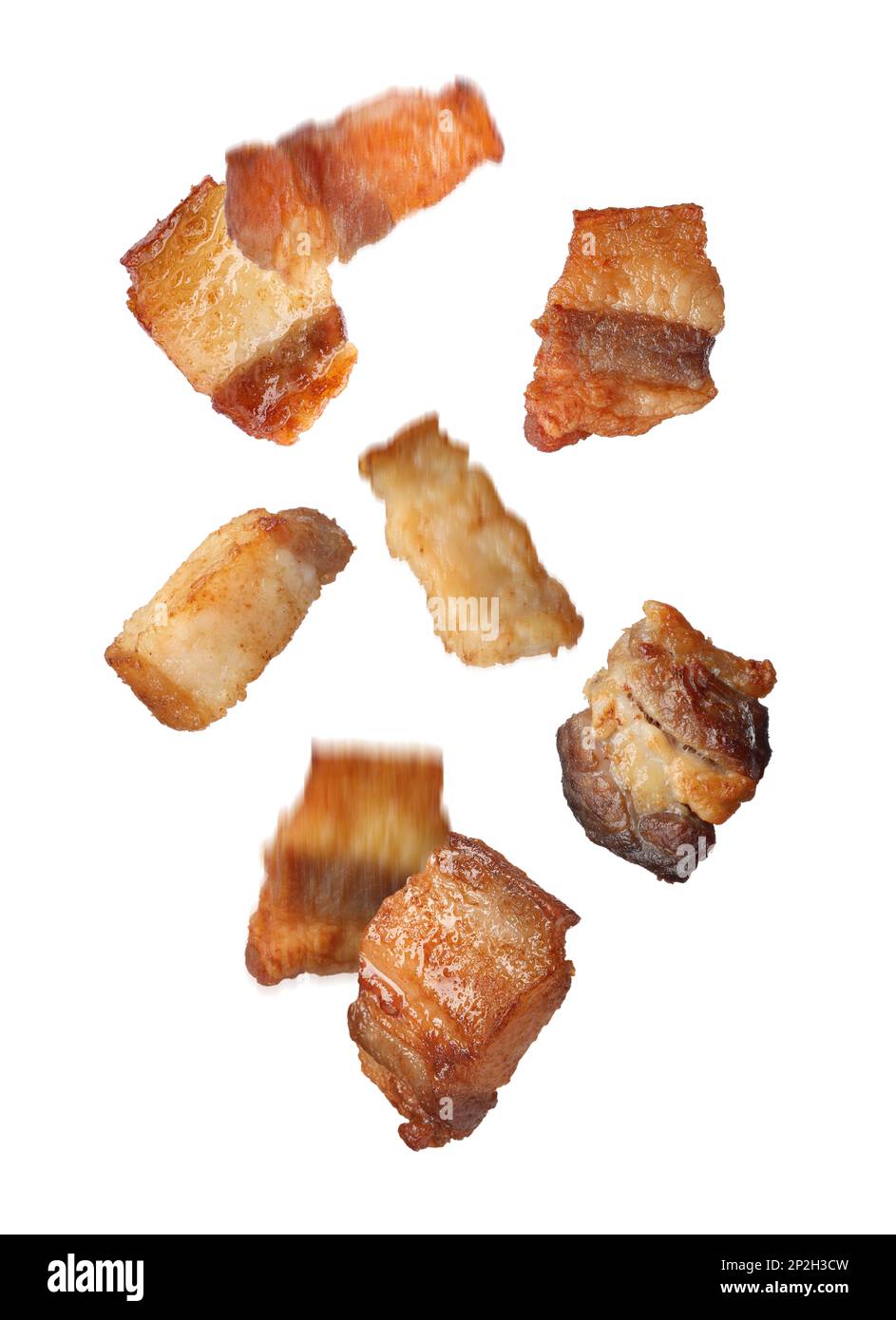 Tasty fried cracklings falling on white background. Cooked pork lard ...