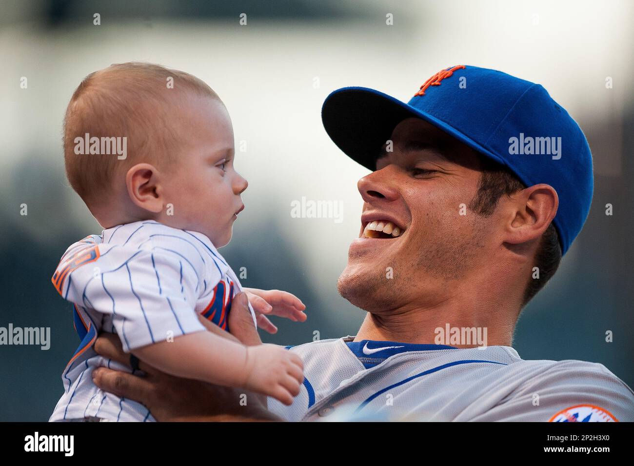 21 AUGUST 2015: New York Mets catcher Anthony Recker (20) holds a baby ...