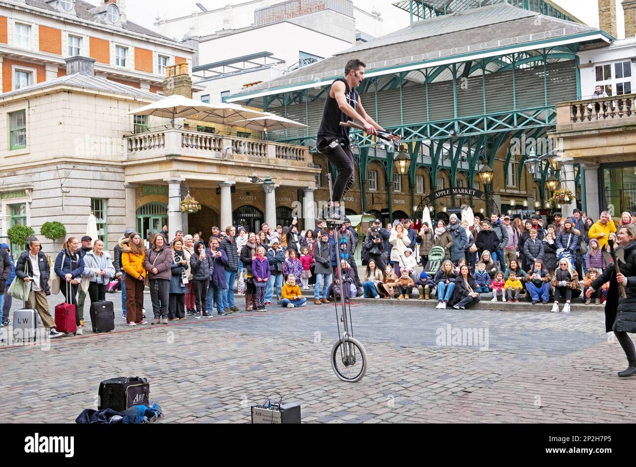 Crowd of people tourists watching live street performer at Covent ...