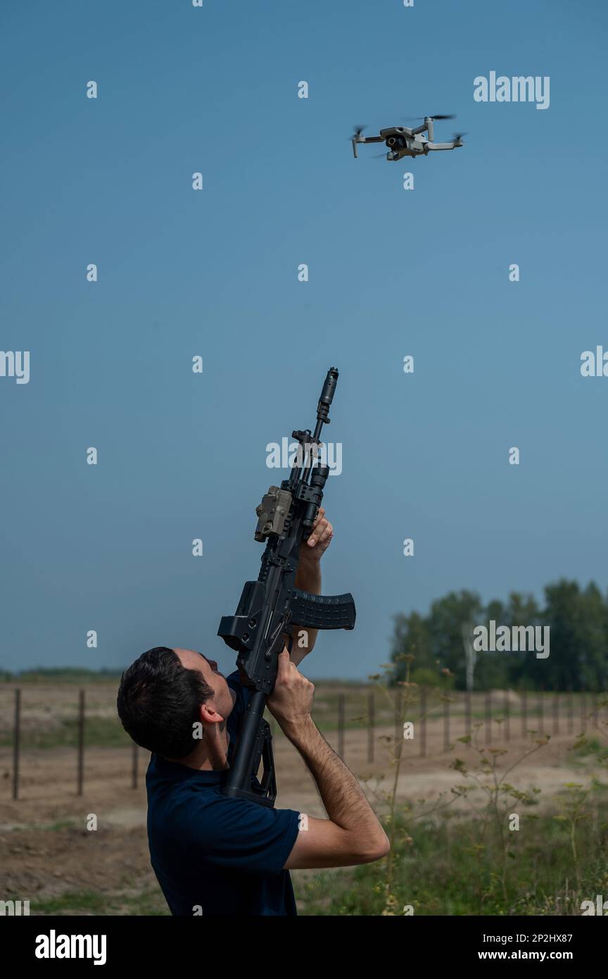 Man aiming to shoot a rifle at a flying drone outdoors Stock Photo - Alamy