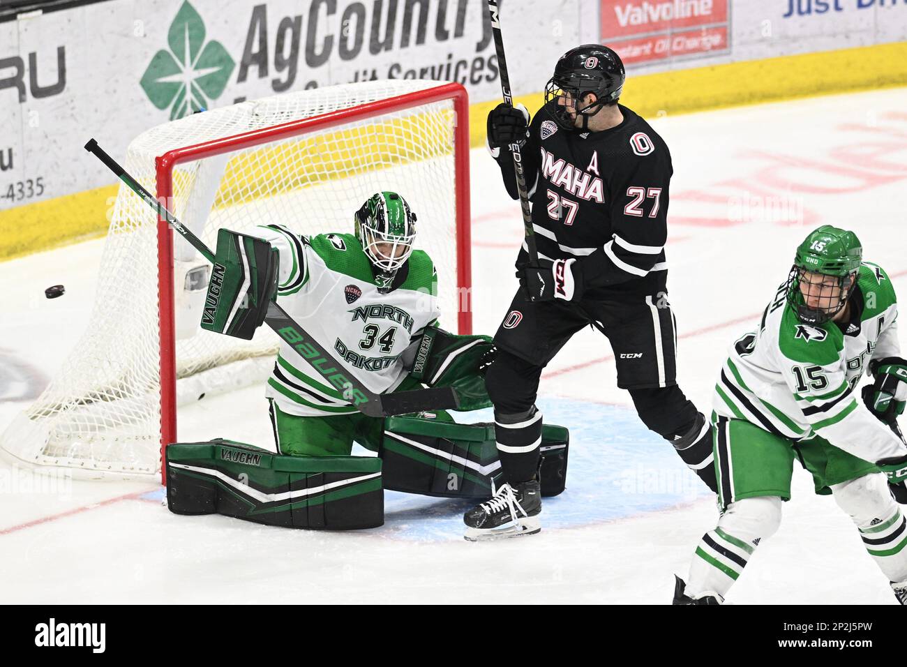 North Dakota Fighting Hawks goaltender Drew DeRidder (34) deflects a shot while being screened ...