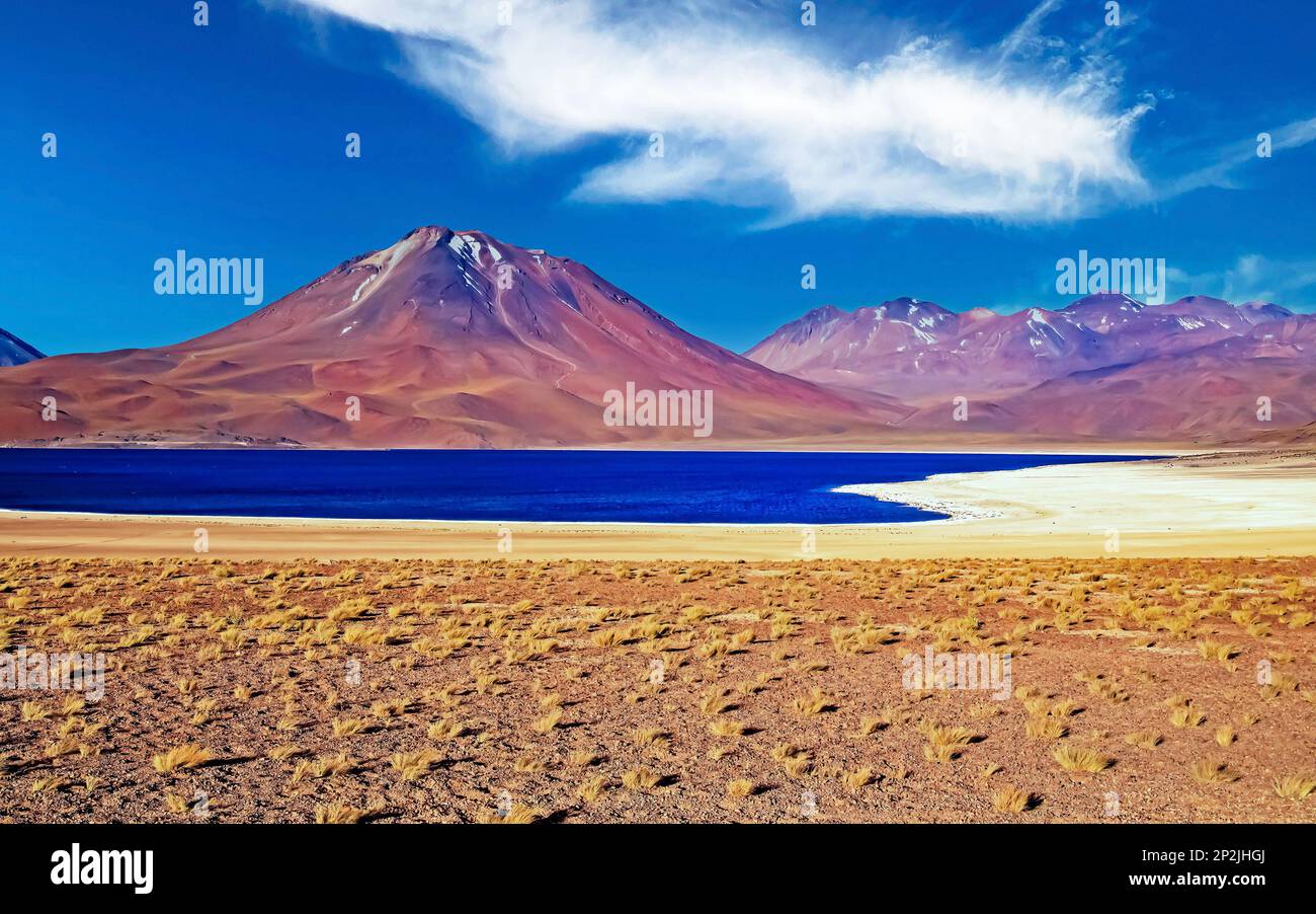 Beautiful wild arid andes high plain landscape, dark blue lake, red ...