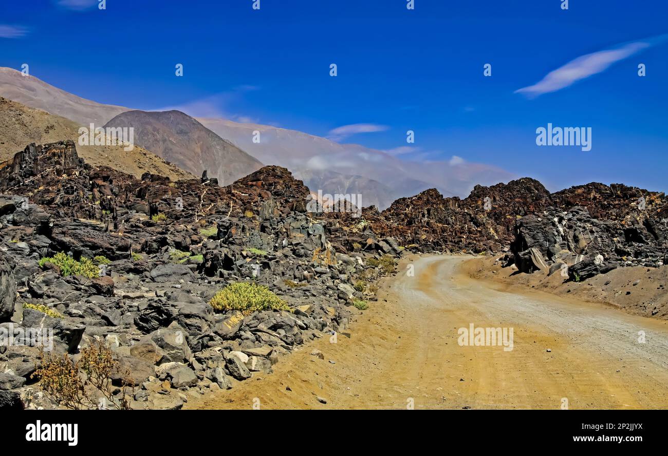 Empty coast sand dirt road track between rocks and mountains in wild ...