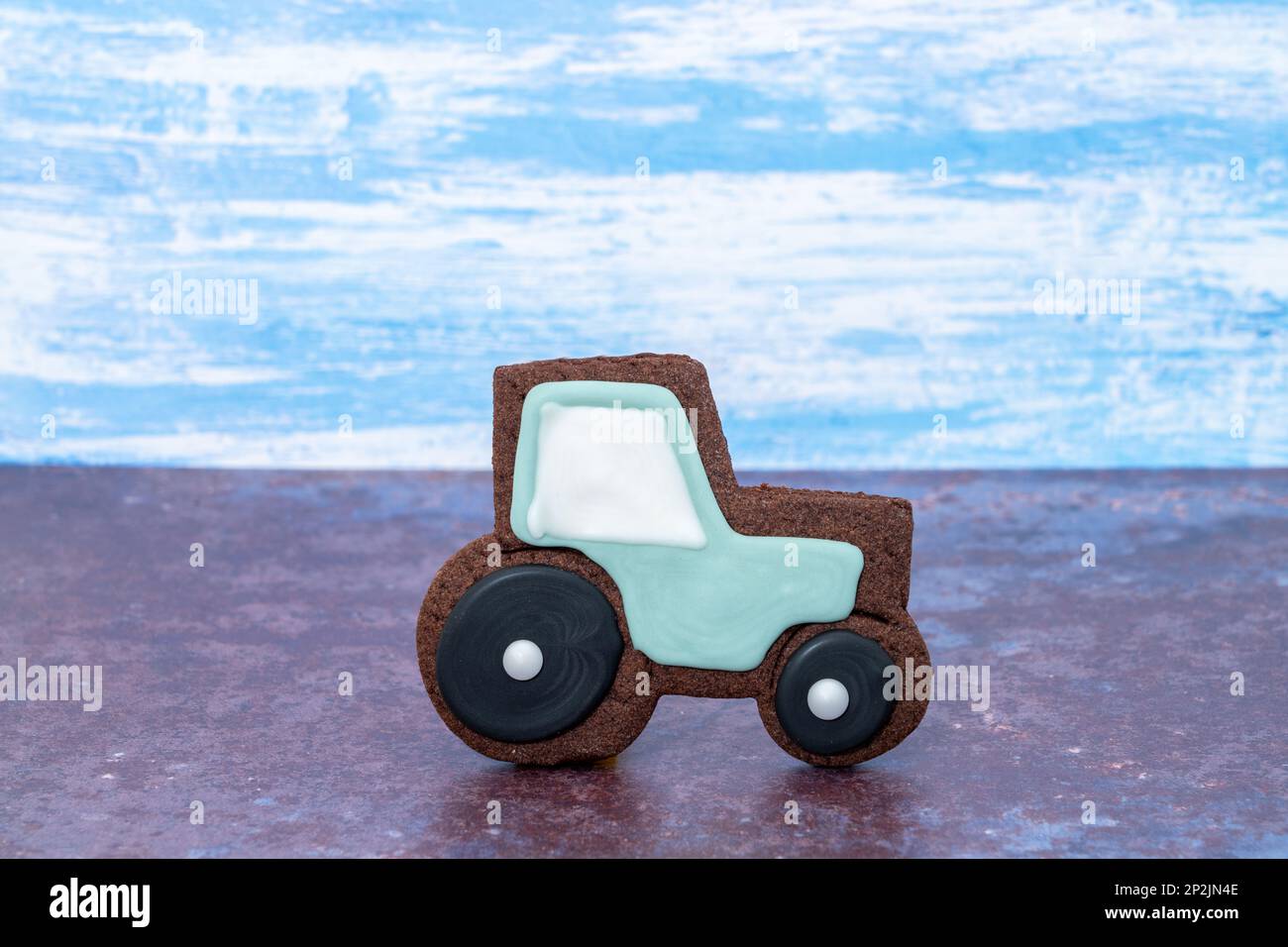 A chocolate cookie with an image of a tractor made with fondant icing ...