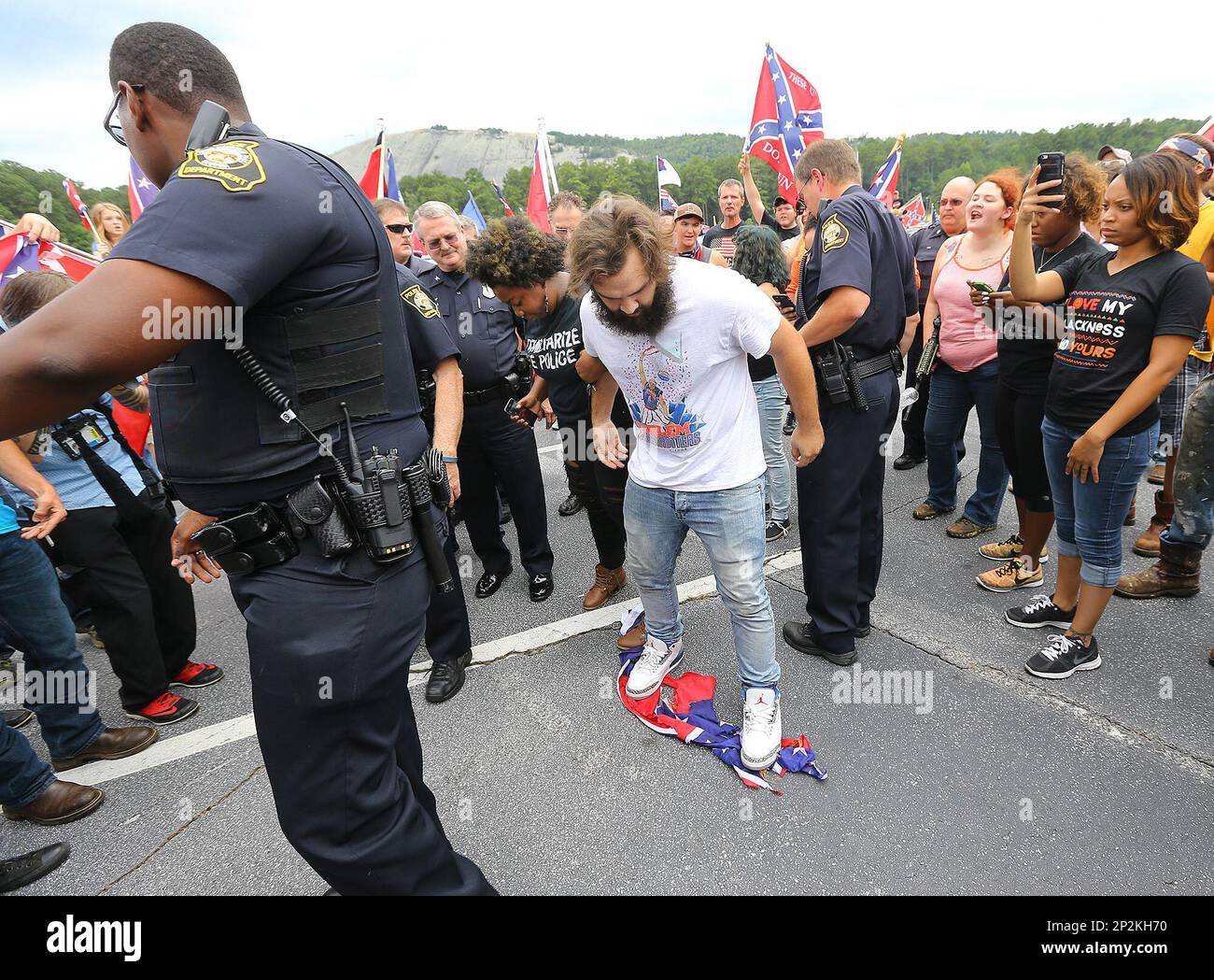 Police surround a pair of counter-protesters who burned and stomped on ...