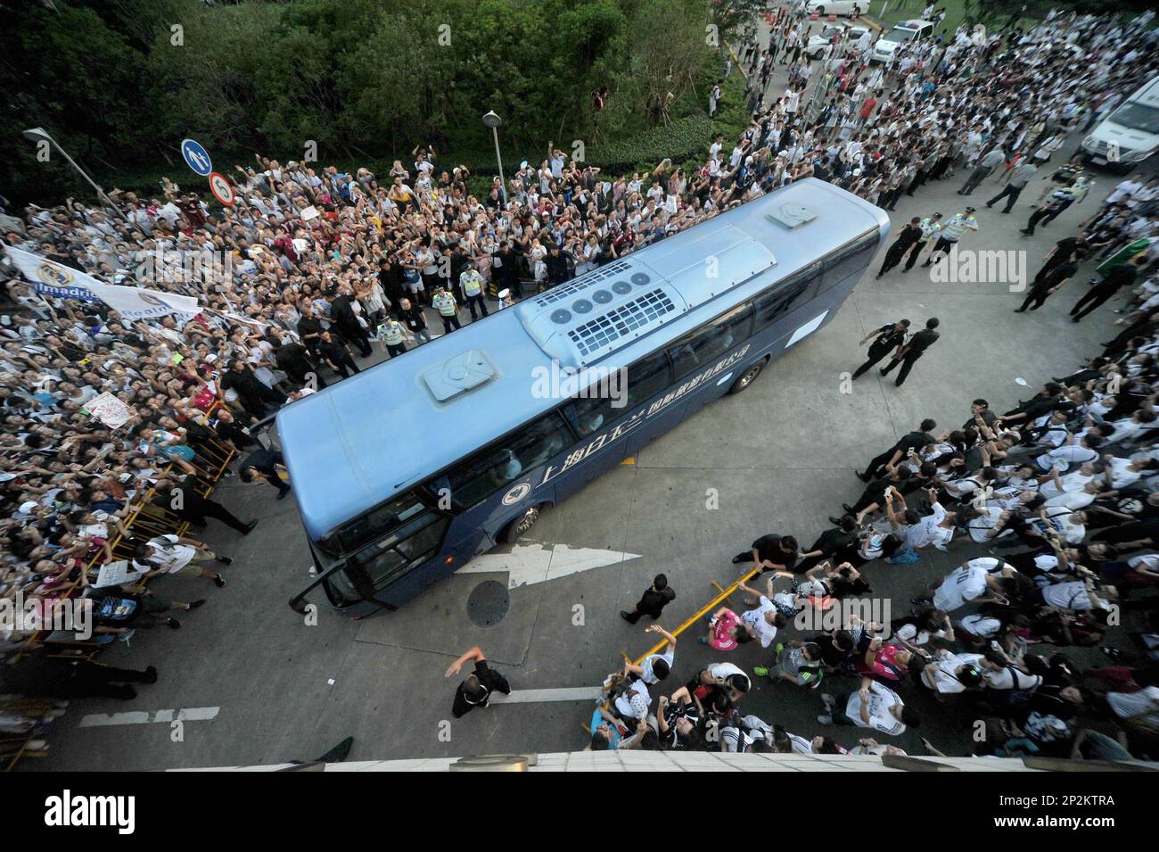 A crowd of football fans watch the arrival of a bus carrying players of ...