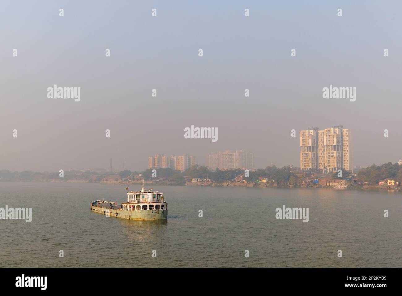 A boat moored and early morning smoggy atmosphere over the Hooghly ...