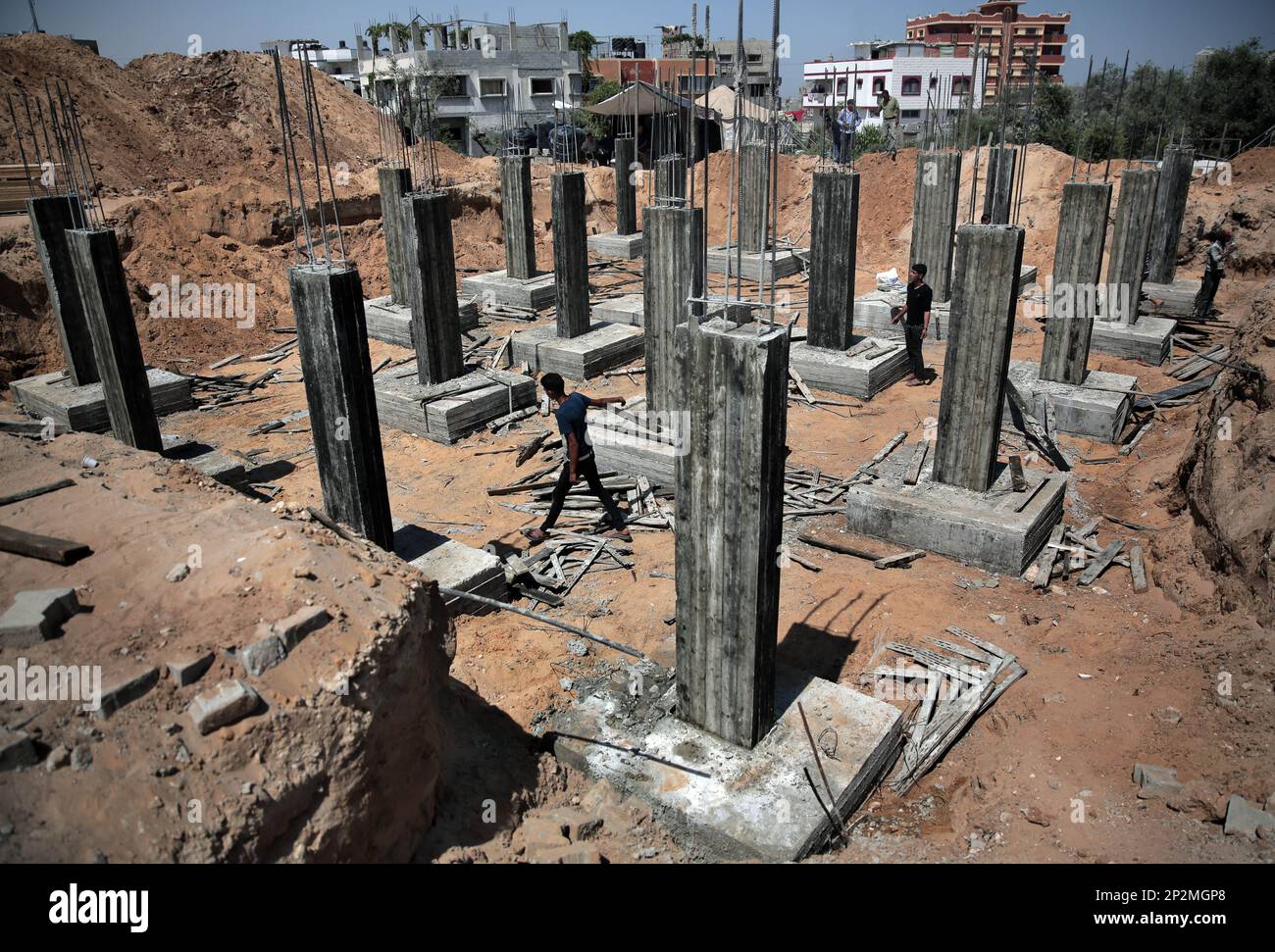Palestinian workers rebuild a house which was destroyed during the last ...
