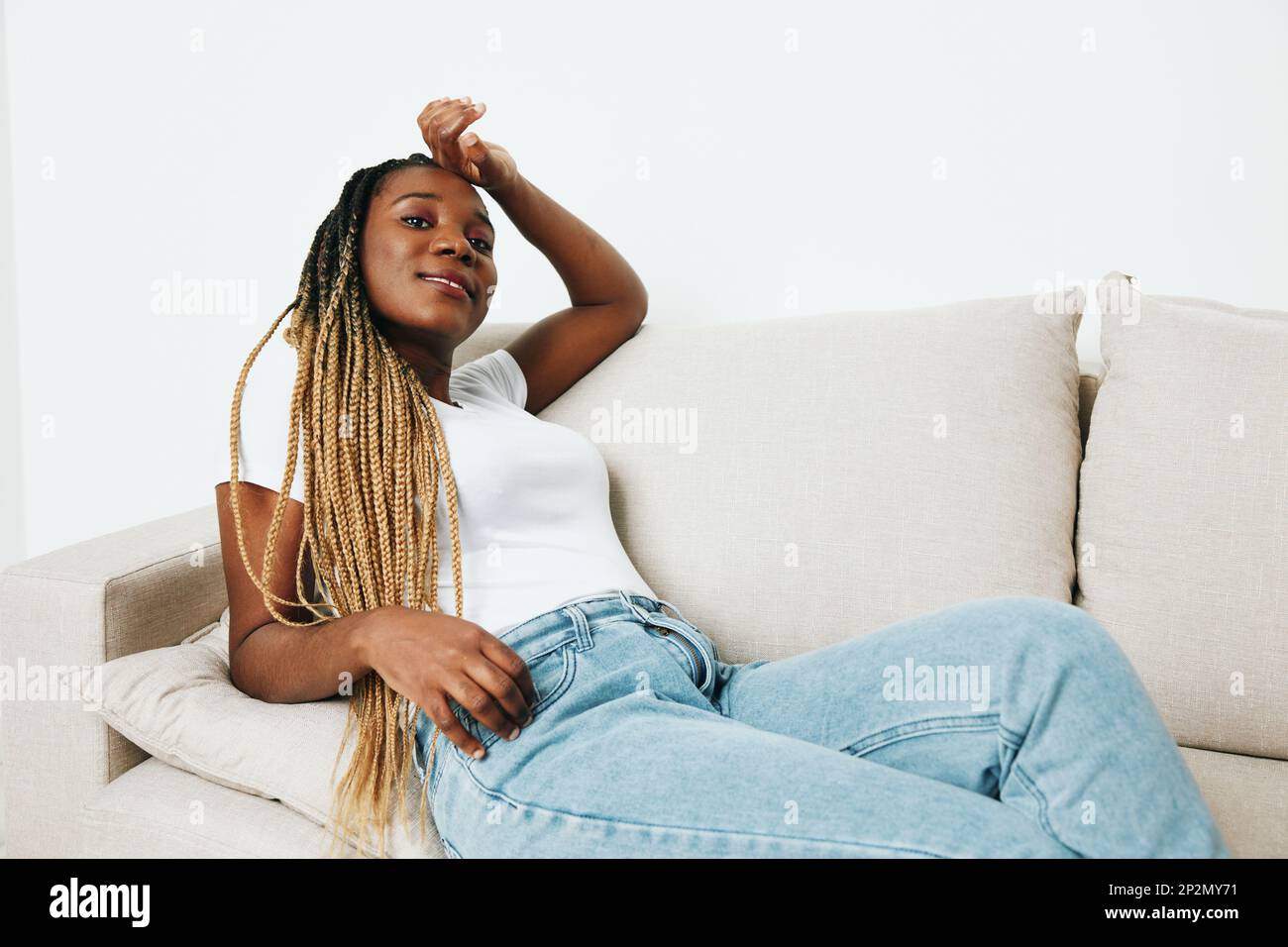 Happy african american woman sitting at home on sofa, rest and vacation ...