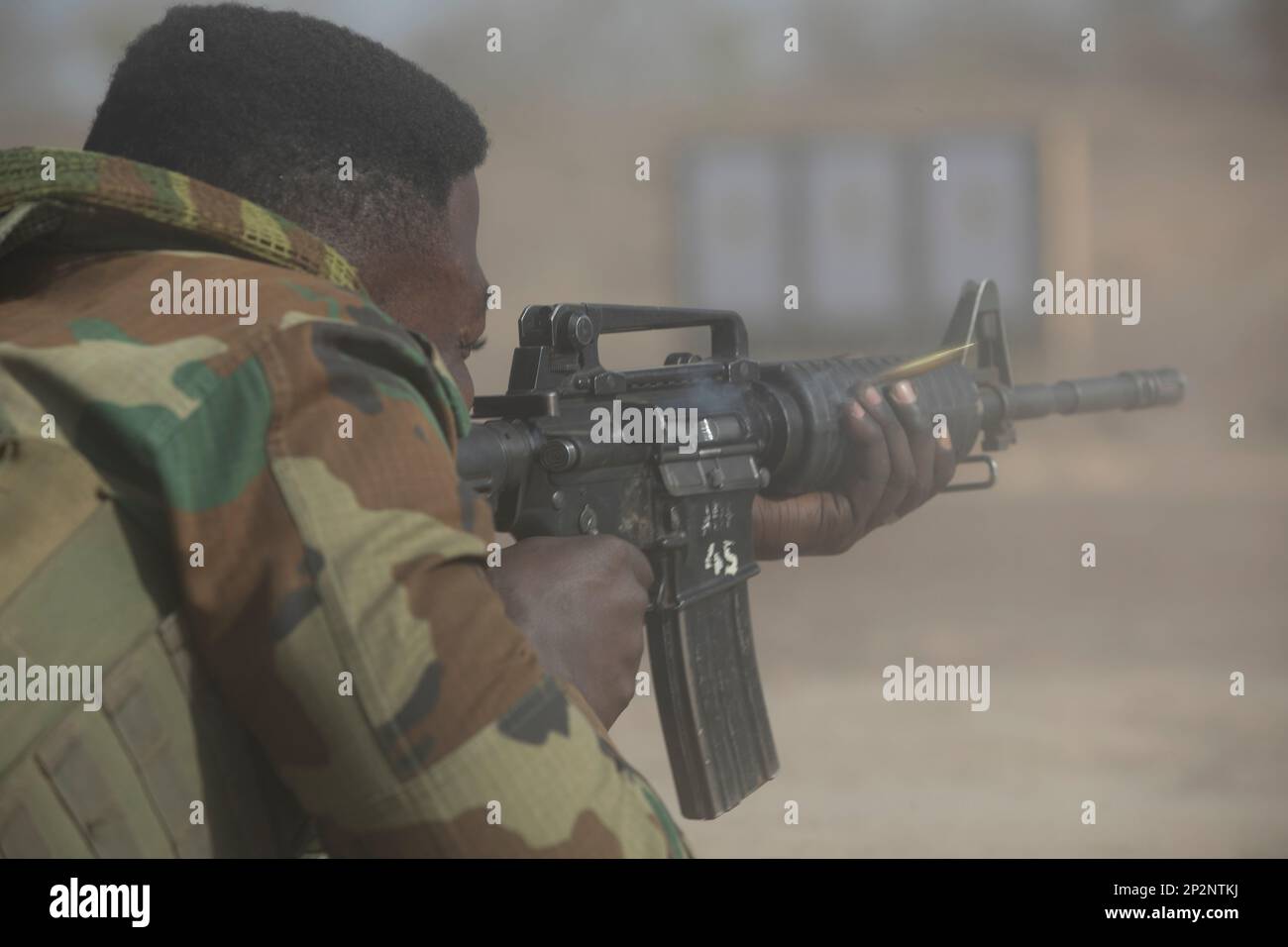 A Ghanaian special forces soldier, fires a rifle while conducting range ...