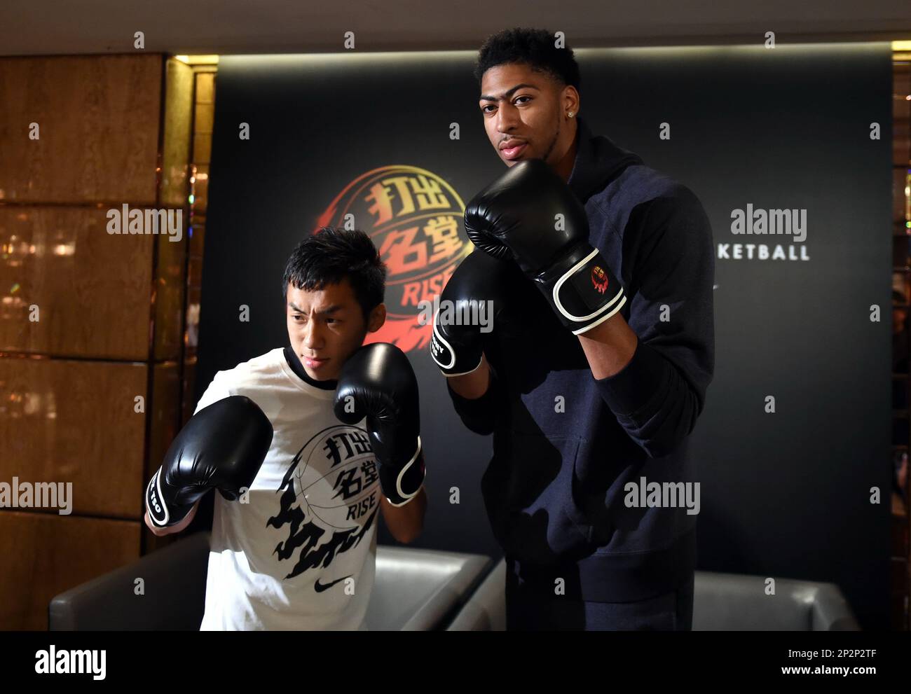 NBA star Anthony Davis, right, wearing boxing gloves poses with Hong ...