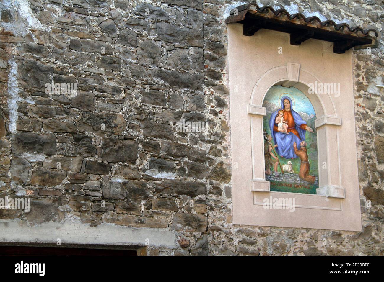 Painting of Madonna with child on the facade of a building in Frisanco ...