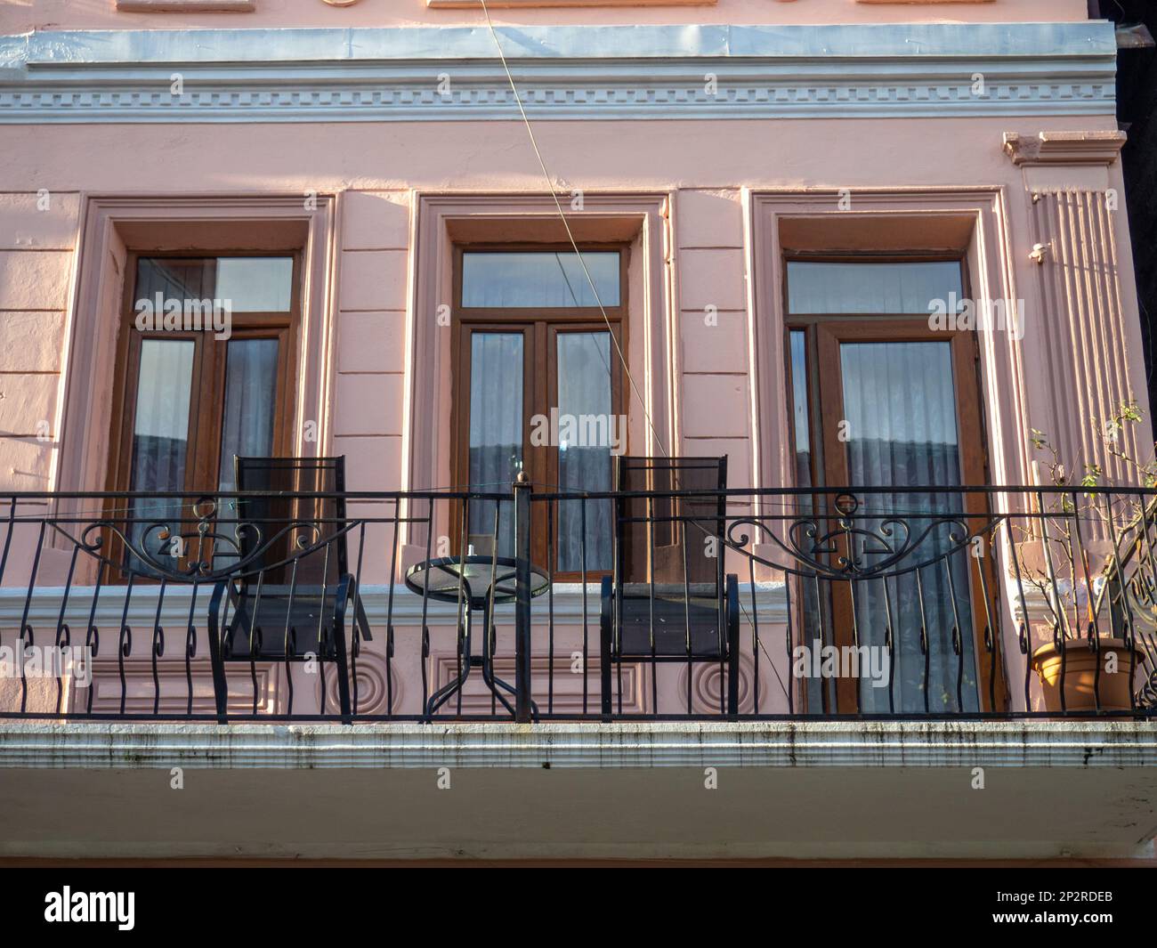 Building's facade. Balcony with chairs and a table on it. Apartments ...
