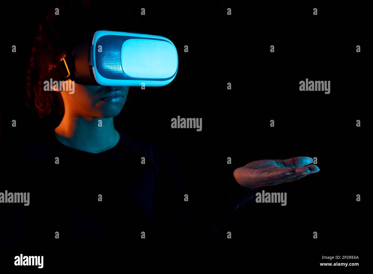Black lady in vr glasses presenting invisible object on her palm hand ...