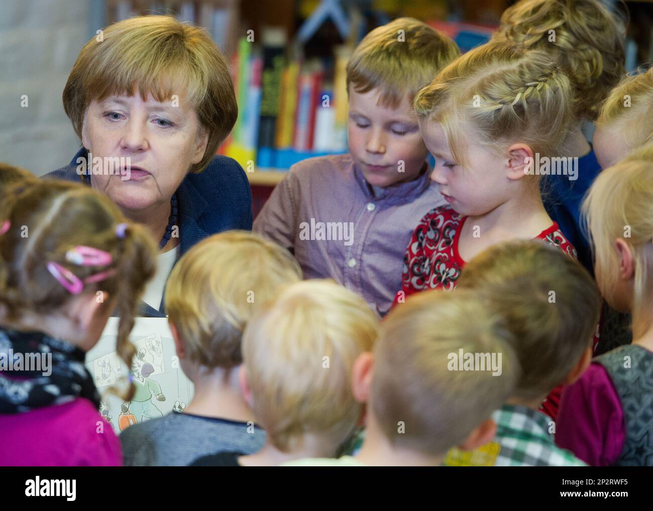 German Chancellor Angela Merkel reads to children during her visit to ...