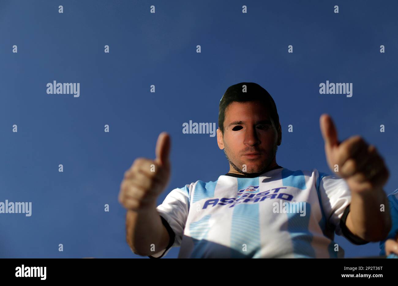 A soccer fan wearing a mask depicting Lionel Messi, flashes two thumbs ...