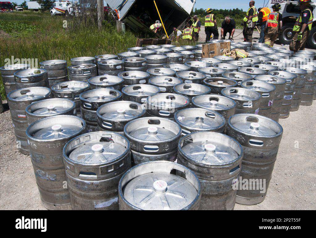 Firefighters remove kegs of beer after a semi-trailer tipped over on ...