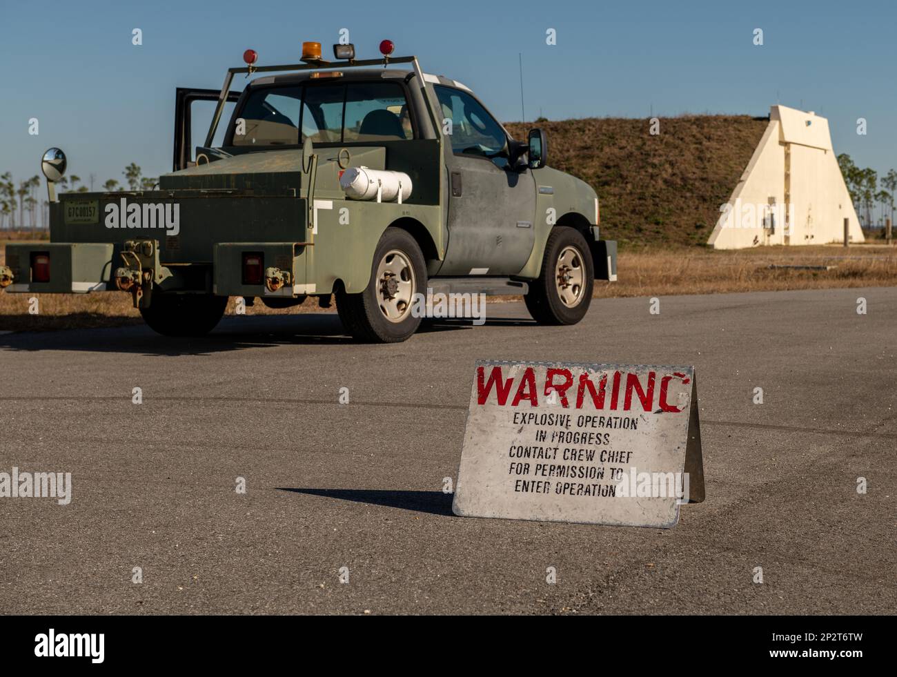 An explosive warning sign sits outside of an igloo during a munitions ...