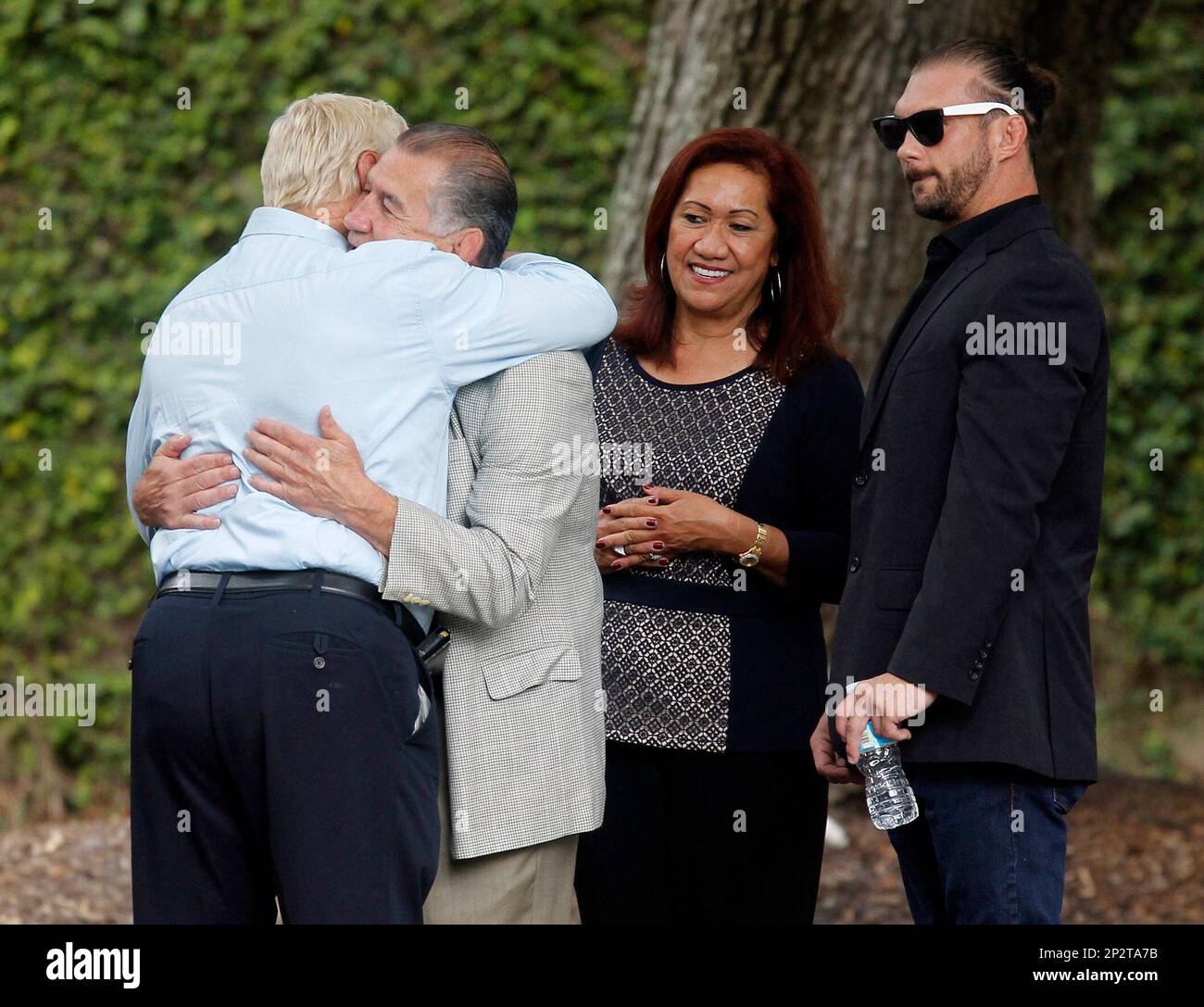 Friends and family members of Dusty Rhodes hug in the parking lot of ...