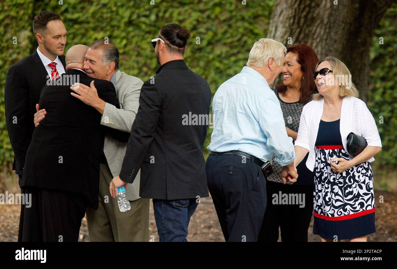 Friends and family members of Dusty Rhodes hug in the parking lot of ...