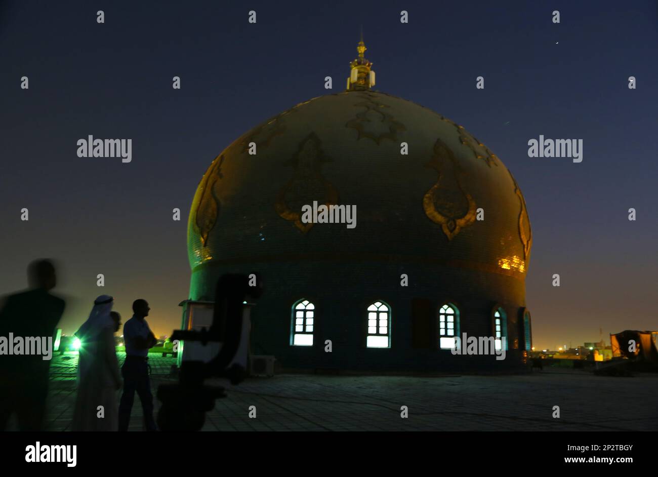 Iraqi Muslim men gather, on the roof of Imam Ali Mosque, waiting to see ...