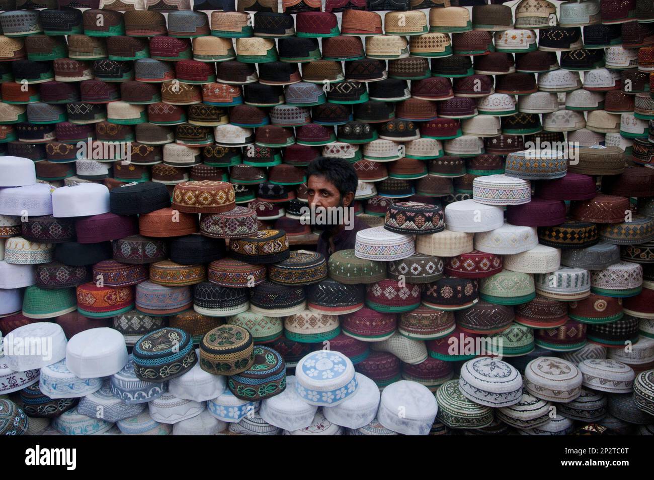 A Pakistani vendor waits for customers to sell caps in Karachi ...