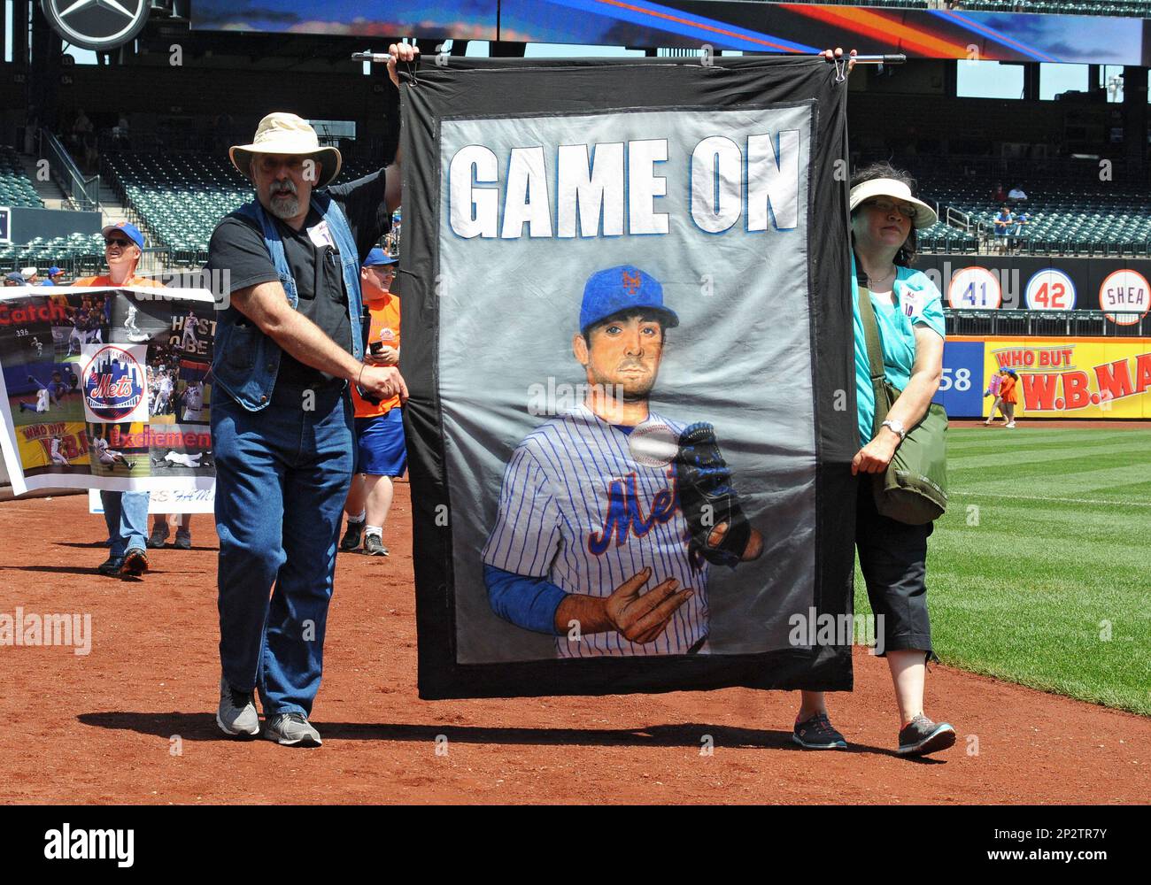 14 June 2015: New York Mets fans show off their banners as they walk ...